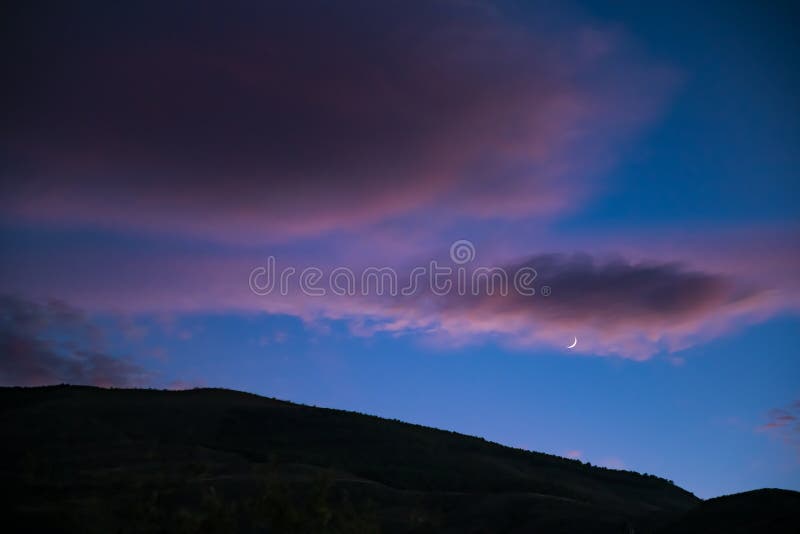 Moon with Clouds at Sunset in a Growing Phase, before Hiding Behind the ...