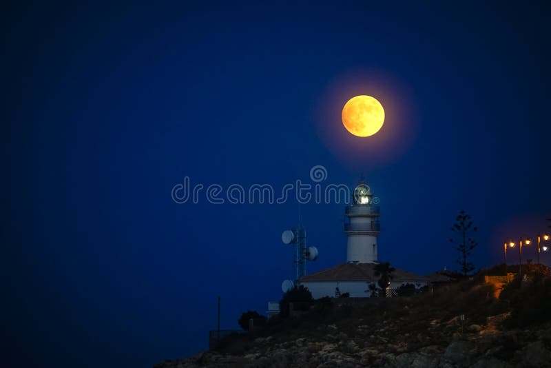 Moon Eclipse Over a Lighthouse on the Coast Stock Photo - Image of ...