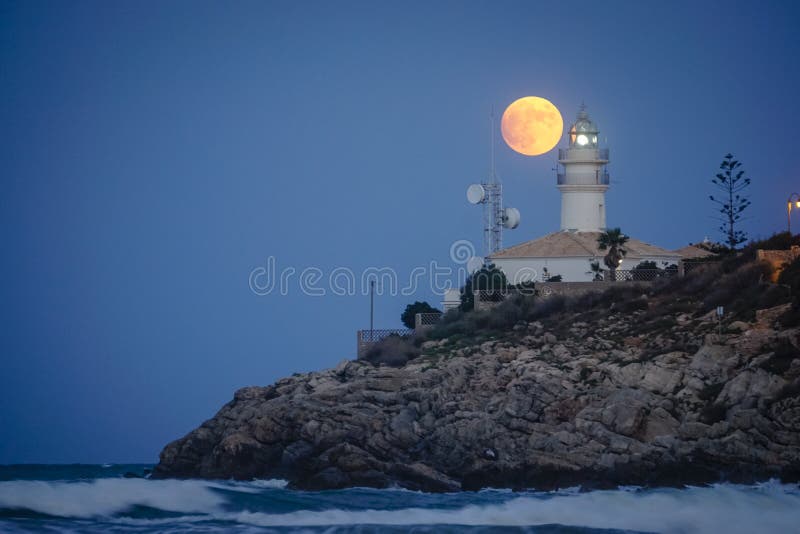 Moon Eclipse Over a Lighthouse on the Coast Stock Photo - Image of ...
