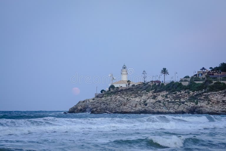 Moon Eclipse Over a Lighthouse on the Coast Stock Photo - Image of ...