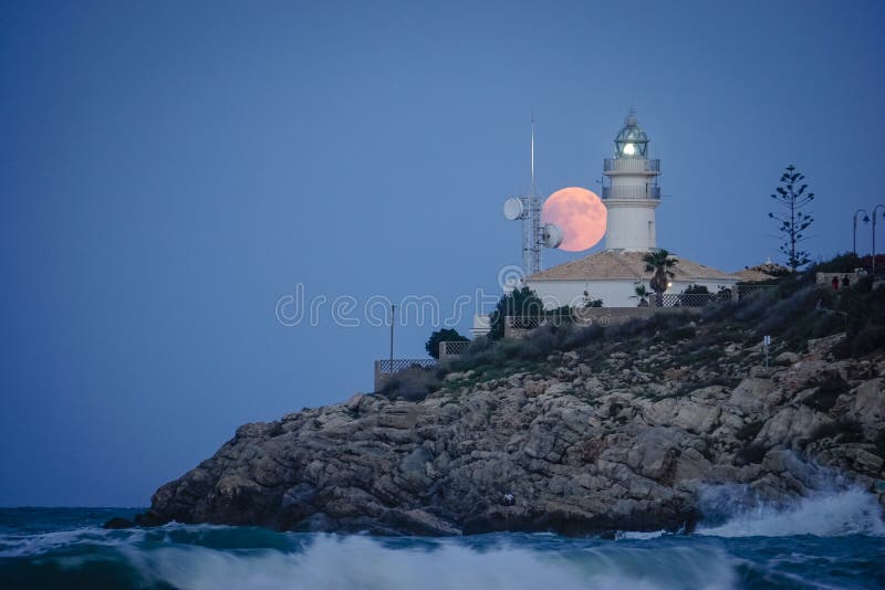 Moon Eclipse Over a Lighthouse on the Coast Stock Photo - Image of ...