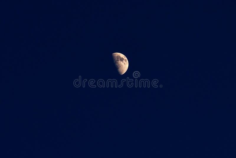The Moon in Half Moon Phase in a Deep Blue Night Sky Stock Image ...