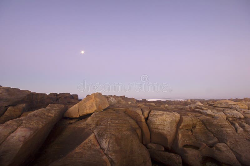 Moon over ocean and rocks stock photo. Image of pastel - 25231124