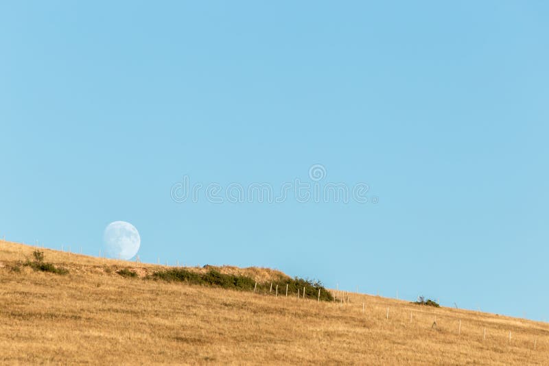 Moon Rising Up Behind an Hill, on an Empty, Blue Sky Stock Photo ...