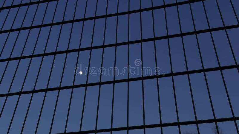 The Moon is Visible through a Grid or Fence, Creating a Boundary Effect ...