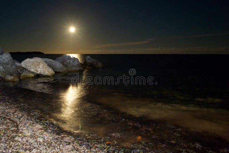 Moonrise over ocean rocks stock image. Image of ocean - 79517443