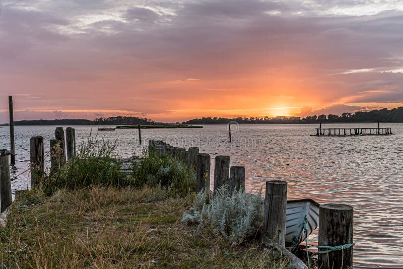 A Moored Rowing Boat at a Jetty of Old Piles in the Sunset Stock Photo ...