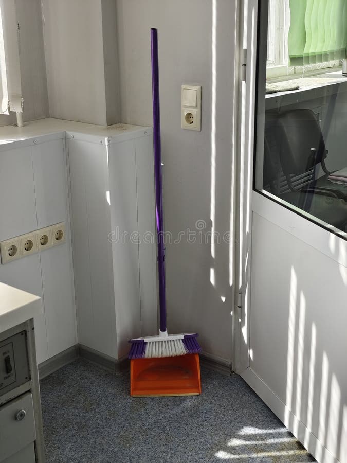 A Mop and a Dustpan for Cleaning the Garbage are in the Corner of the ...
