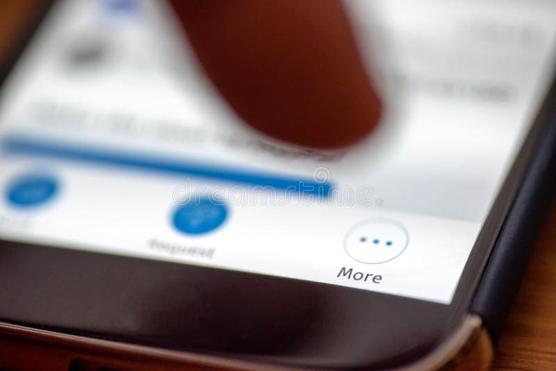 More Button on Smartphone Screen Closeup with Human Finger Pointing To ...