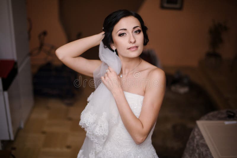 Morning of the Bride. Beautiful Young Woman in Elegant White Robe with ...