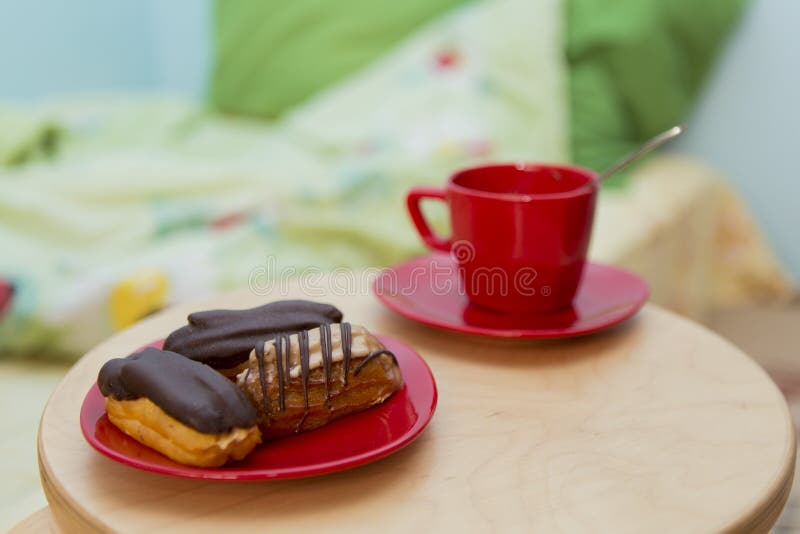 A Mug of Coffee, and Eclairs on a Chair Near the Bed Stock Photo ...