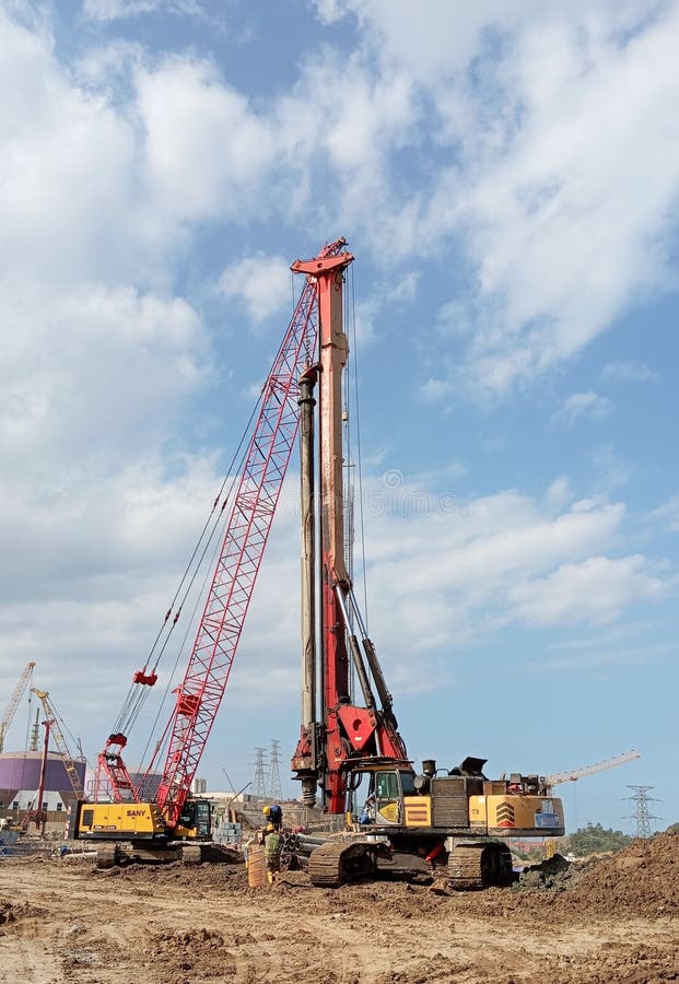 A Crane Operates at the Project Site with a Sky Blue Background ...