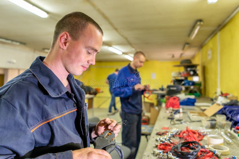 Small Cable Installation Plant. Electric Workshop Workers Knit a Cable ...
