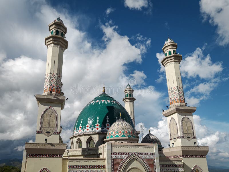 Photo of a Mosque with a Tall Tower Against a Blue Sky with White ...