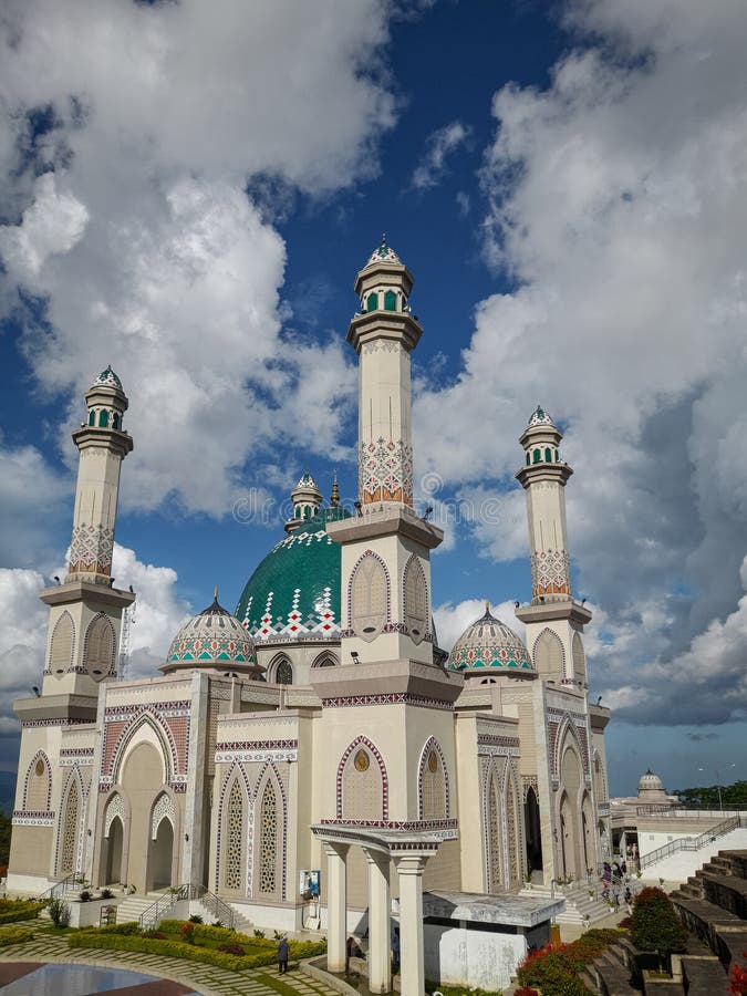 Photo of a Mosque with a Tall Tower Against a Blue Sky with White ...