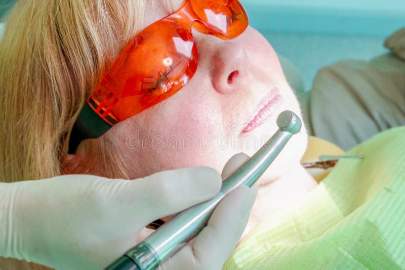 Dentist Drilling Tooth of a Female Patient. Use a High Volume Dental ...