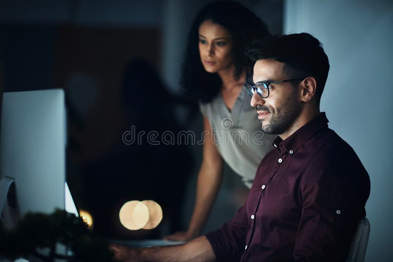 The Most Focused Team on a Late Night Task. Two Colleagues Using a ...