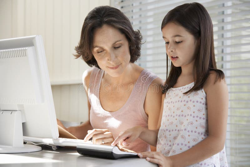 Mother Assisting Daughter in Using Computer and Calculator Stock Image ...