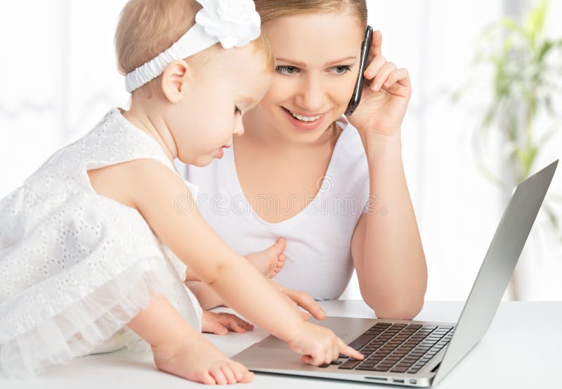 Mother with Baby Daughter Works with a Computer and Phone Stock Image ...