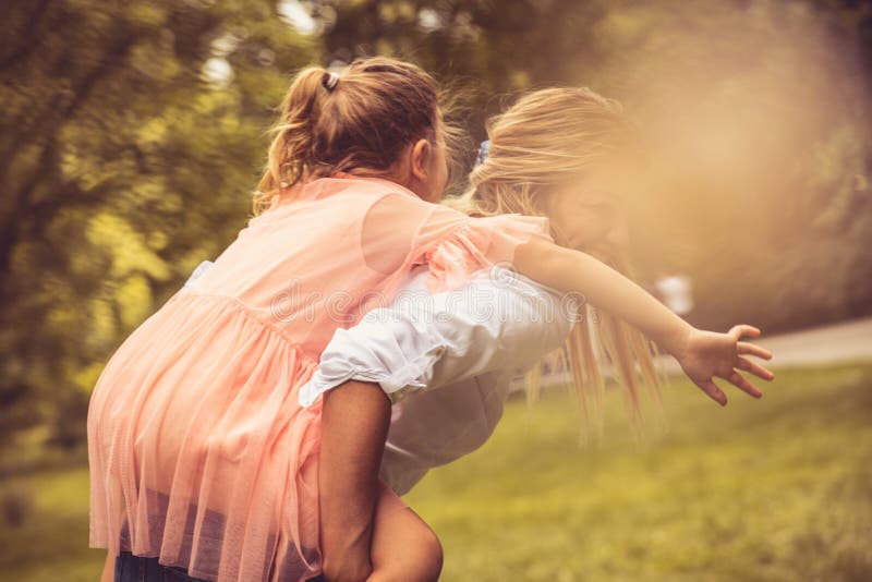 Mother Carrying Her Daughter on a Piggyback. Stock Photo - Image of ... Mother Carrying Her Daughter on a Piggyback. Stock Photo - Image of ...