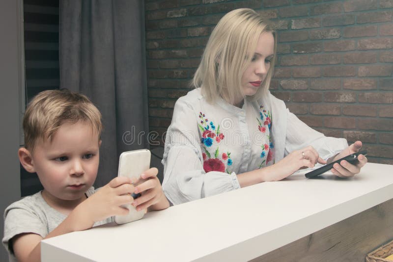 Mother and Child with Mobile Phones. the Concept of Dependence on the ...