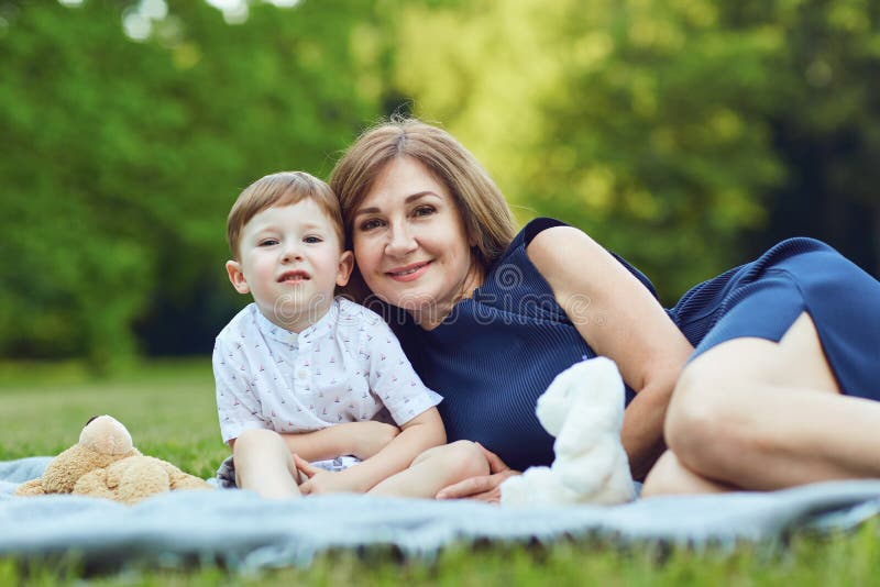 Mother with Child Sitting on Grass in Park Stock Image - Image of ...