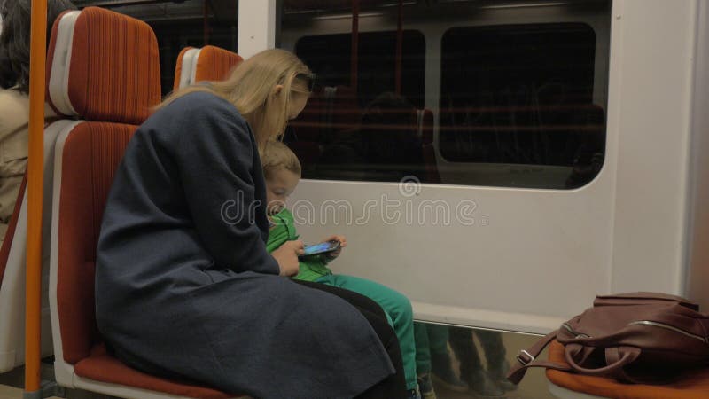 Mother and Child Using Cell in Moving Subway Train Stock Video - Video ...