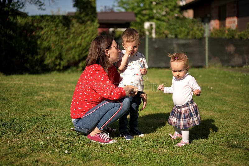 Mother with Children Playing in the Back Yard Stock Photo - Image of ...