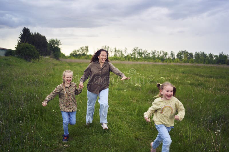 Mother and Children Run Holding Hands in the Field Stock Image - Image ...