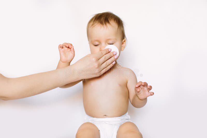Mother Cleaning Eyes of a Newborn Baby with Physiological Solution on a ...