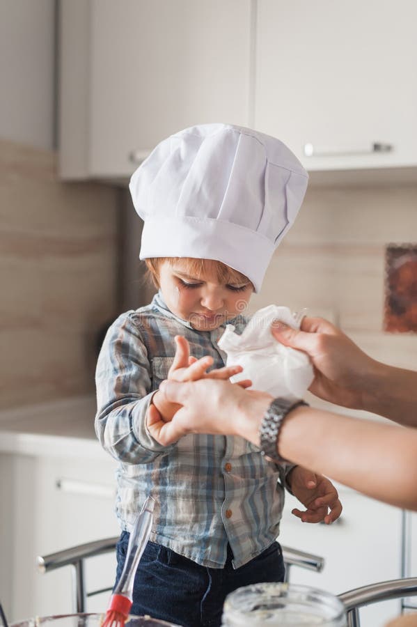 Mother Cleaning Hands of Child in Chef Hat Stock Photo - Image of ...