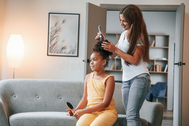Mother Is Combs Hair Young Woman With Her Daughter Is Together At