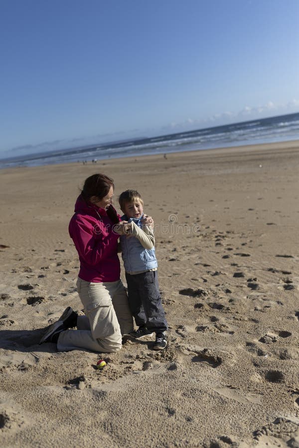 Mother Comforting Her Son on a Sunny Beach Stock Photo - Image of ...