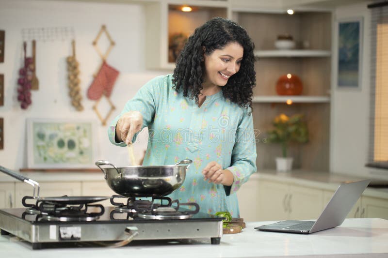 Mother Cooking in the Kitchen Watching Video Recipe on Laptop Stock ...