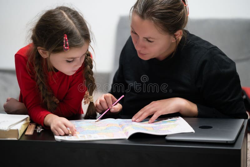 Mother and Daughter Collaborating on a School Project on the Table ...