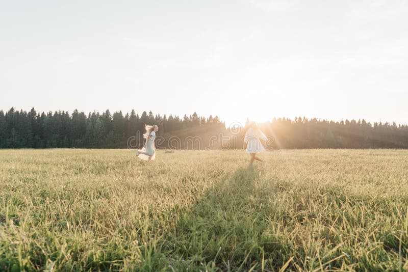 Mother and Daughter Dance in Field, Sunset Light. Stock Photo - Image ...