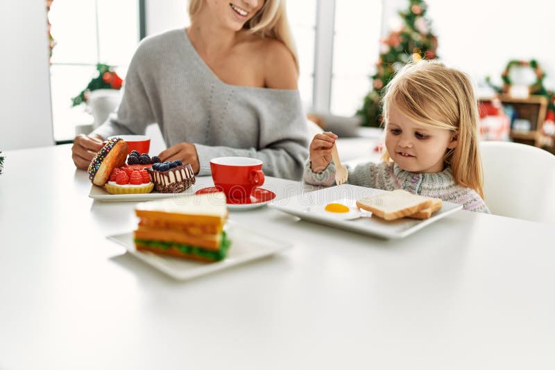 Mother and Daughter Having Breakfast Sitting by Christmas Tree at Home ...