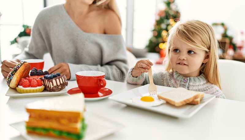 Mother and Daughter Having Breakfast Sitting by Christmas Tree at Home ...