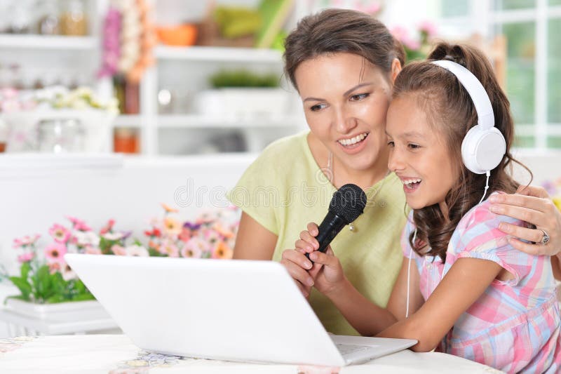 Mother and Daughter Looking at Laptop Singing Karaoke Stock Photo ...