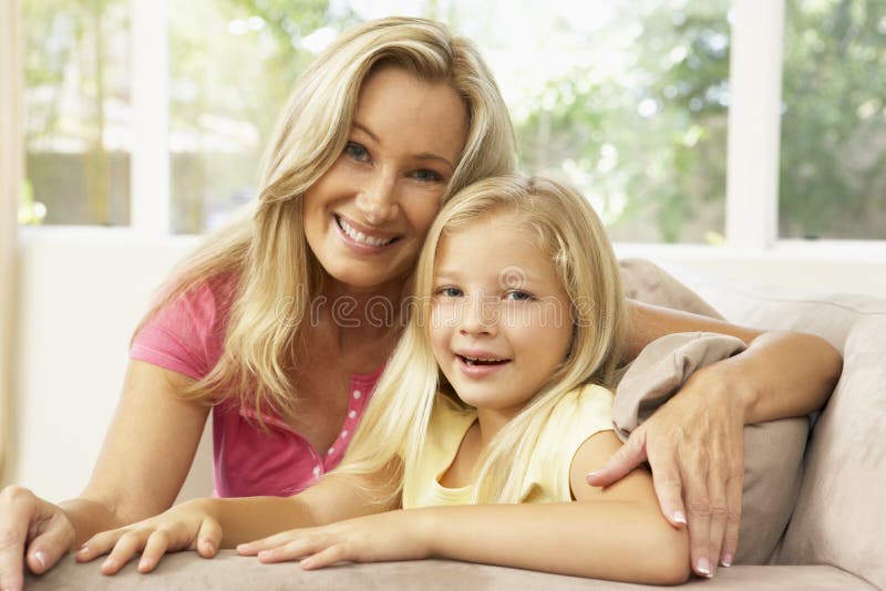Mother And Daughter Relaxing On Sofa At Home Stock Image Image Of