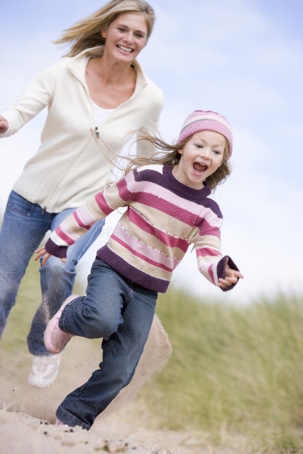 Mother and Daughter Running on Beach Smiling Stock Photo - Image of ...