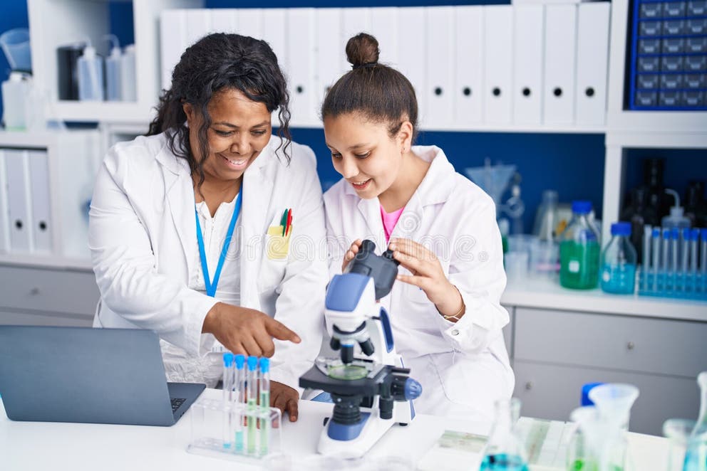 Mother and Daughter Scientists Using Microscope and Laptop Working at ...