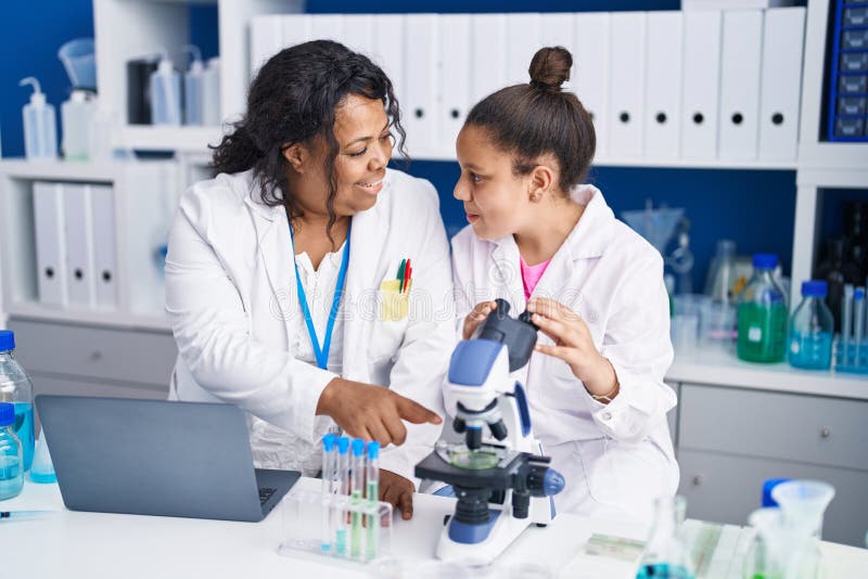 Mother and Daughter Scientists Using Microscope and Laptop Working at ...