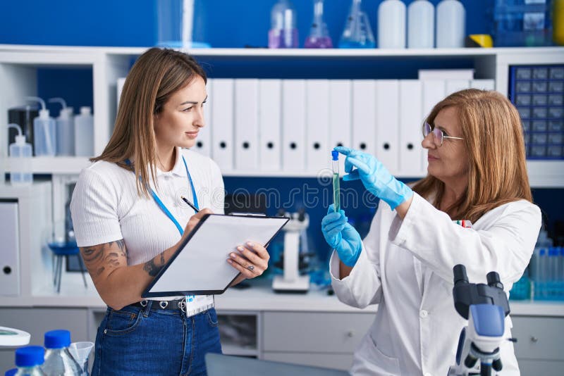 Mother and Daughter Scientists Writing on Document Holding Test Tube at ...
