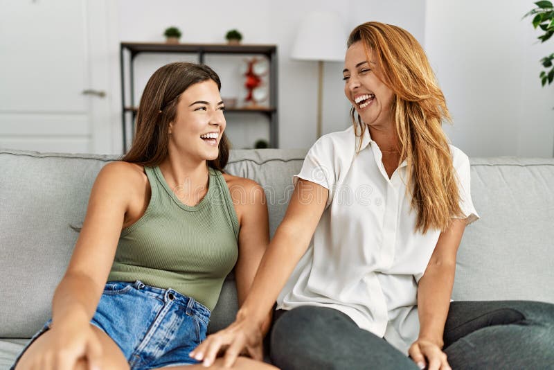 Mother And Daughter Smiling Confident Sitting On Sofa At Home Stock
