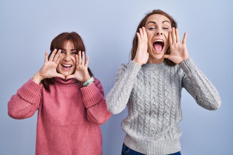 Mother And Daughter Standing Over Blue Background Smiling Cheerful