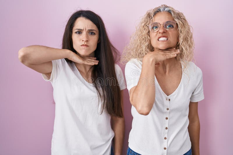 Mother And Daughter Standing Together Over Pink Background Cutting