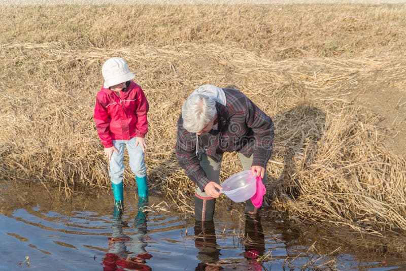Mother and Daughter Standing in Water Stock Photo - Image of boots ...