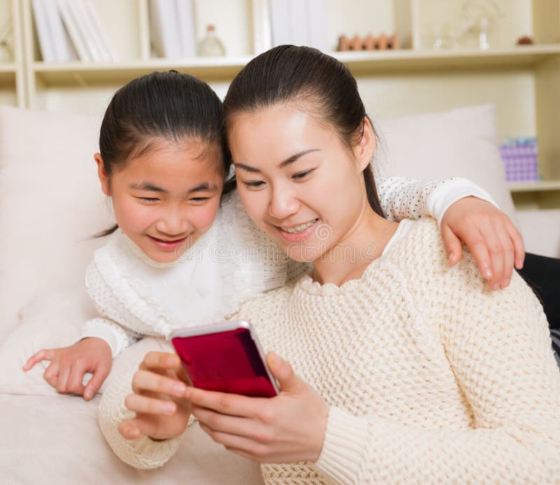 Mother and Daughter Using Smart Phone Stock Photo - Image of house ...