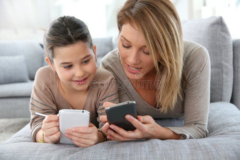 Mother and Daughter Using Smartphones Stock Photo - Image of interiors ...